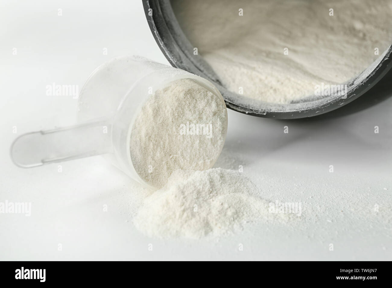 Protein powder and scoop on white background Stock Photo - Alamy