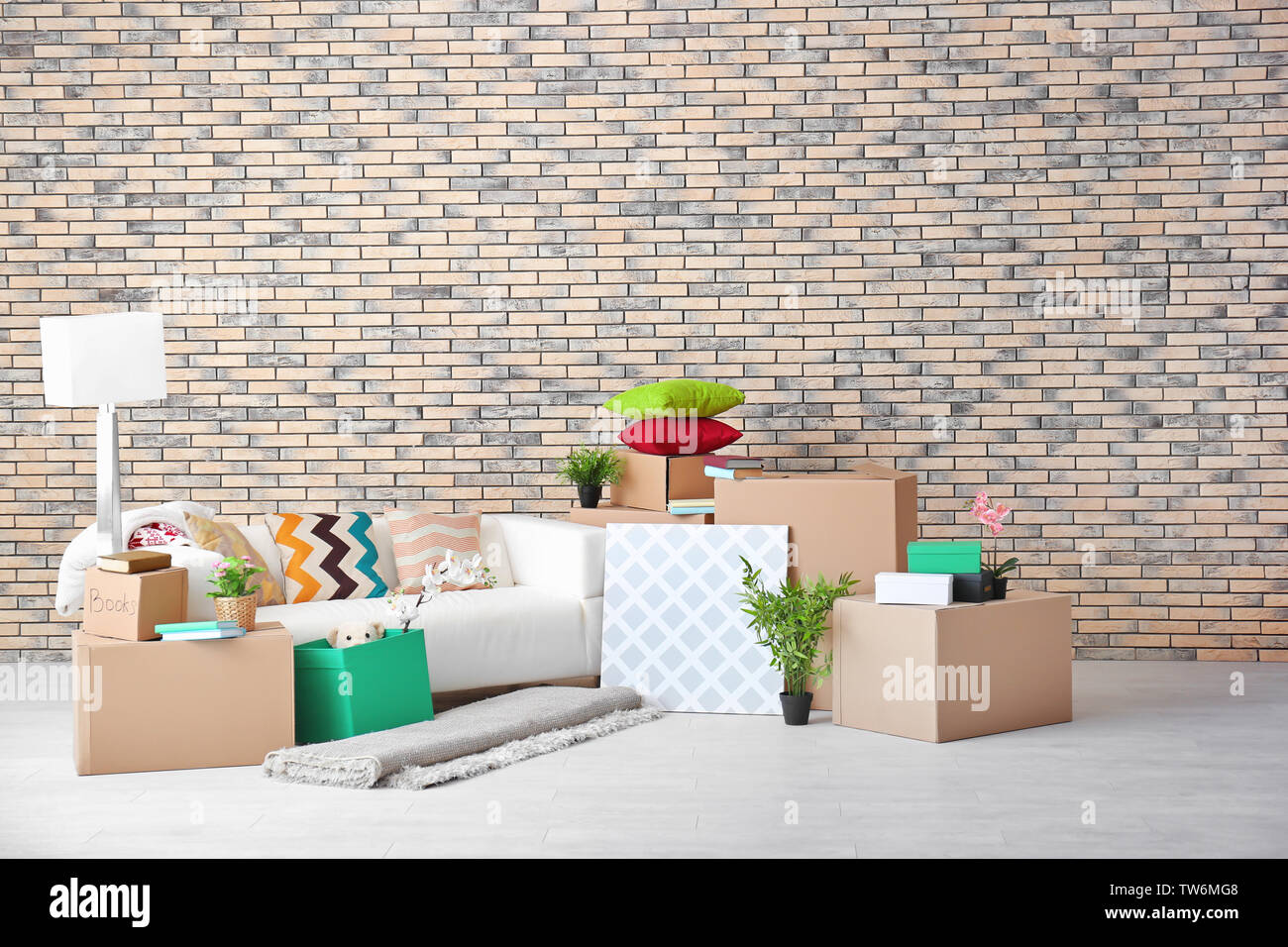 Sofa, carton boxes and interior items in room. Moving house concept ...