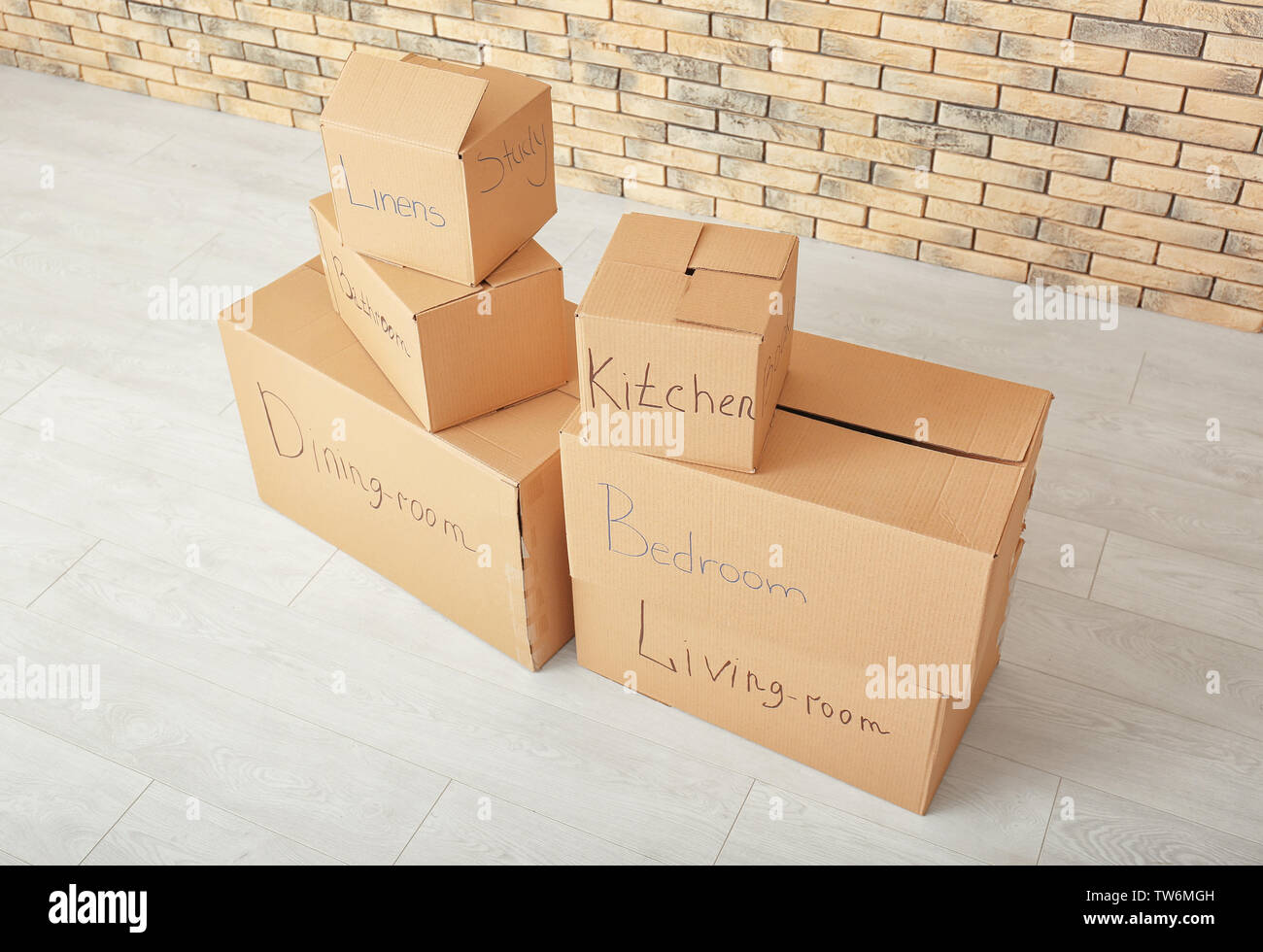 Carton boxes on floor in room. Moving house concept Stock Photo - Alamy