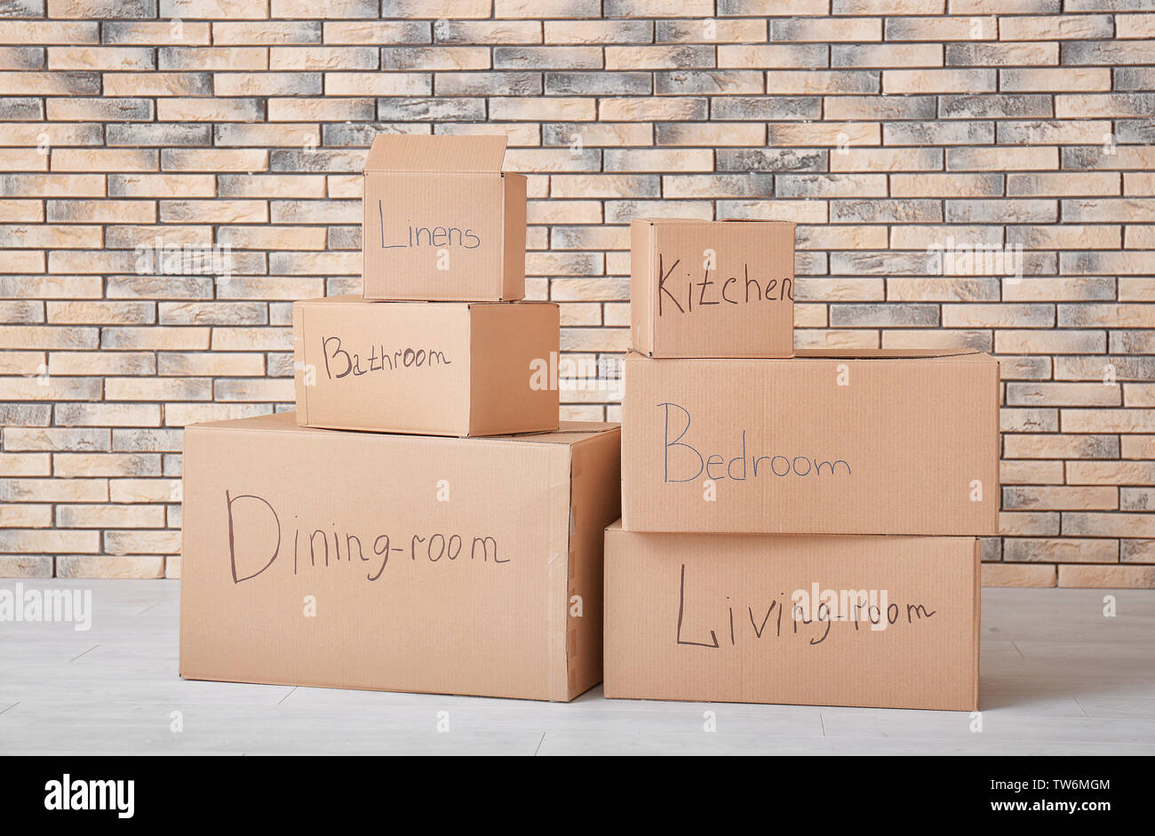 Carton boxes on floor in room. Moving house concept Stock Photo - Alamy