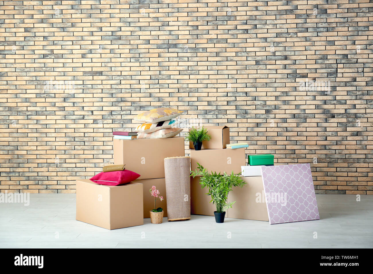 Carton boxes and interior items on floor in room. Moving house concept ...