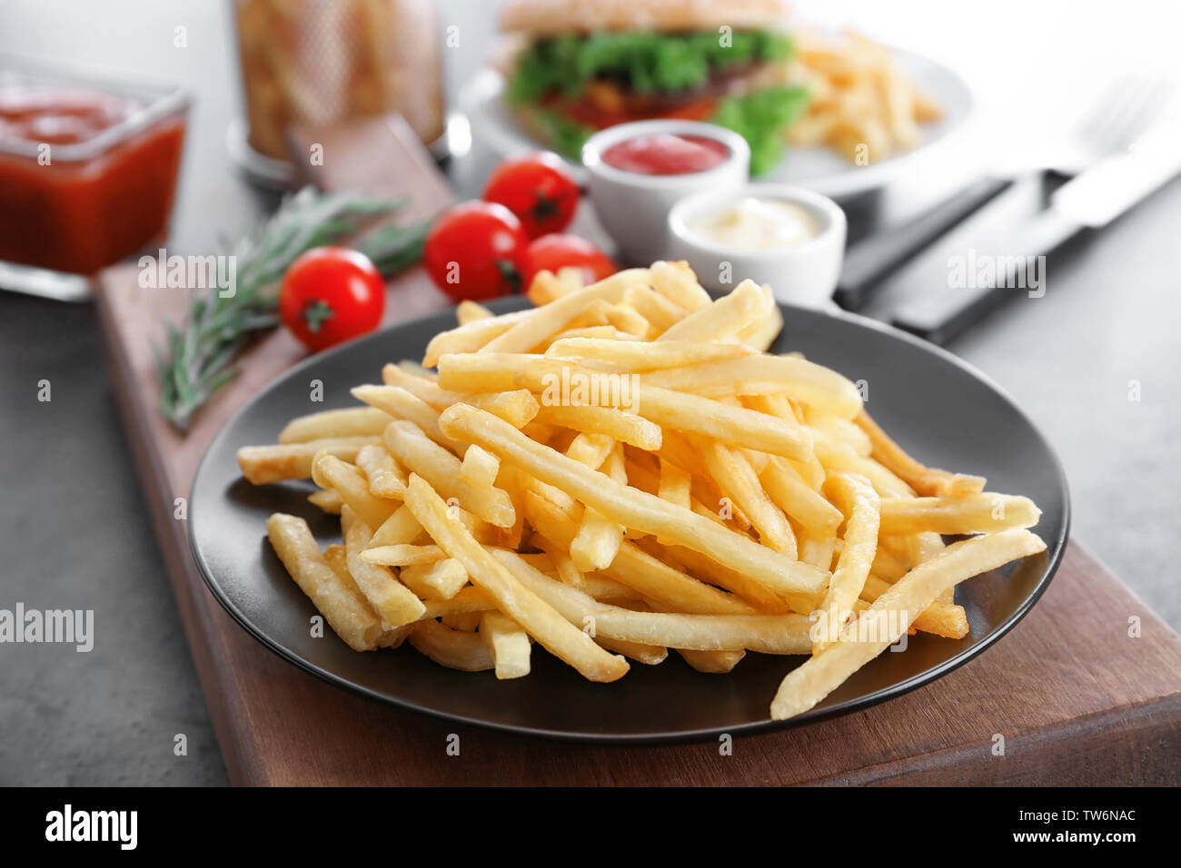 Plate with yummy french fries on table Stock Photo - Alamy