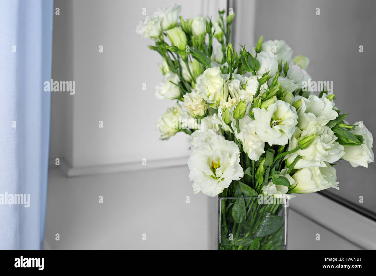 Vase with beautiful eustoma flowers on window sill Stock Photo - Alamy