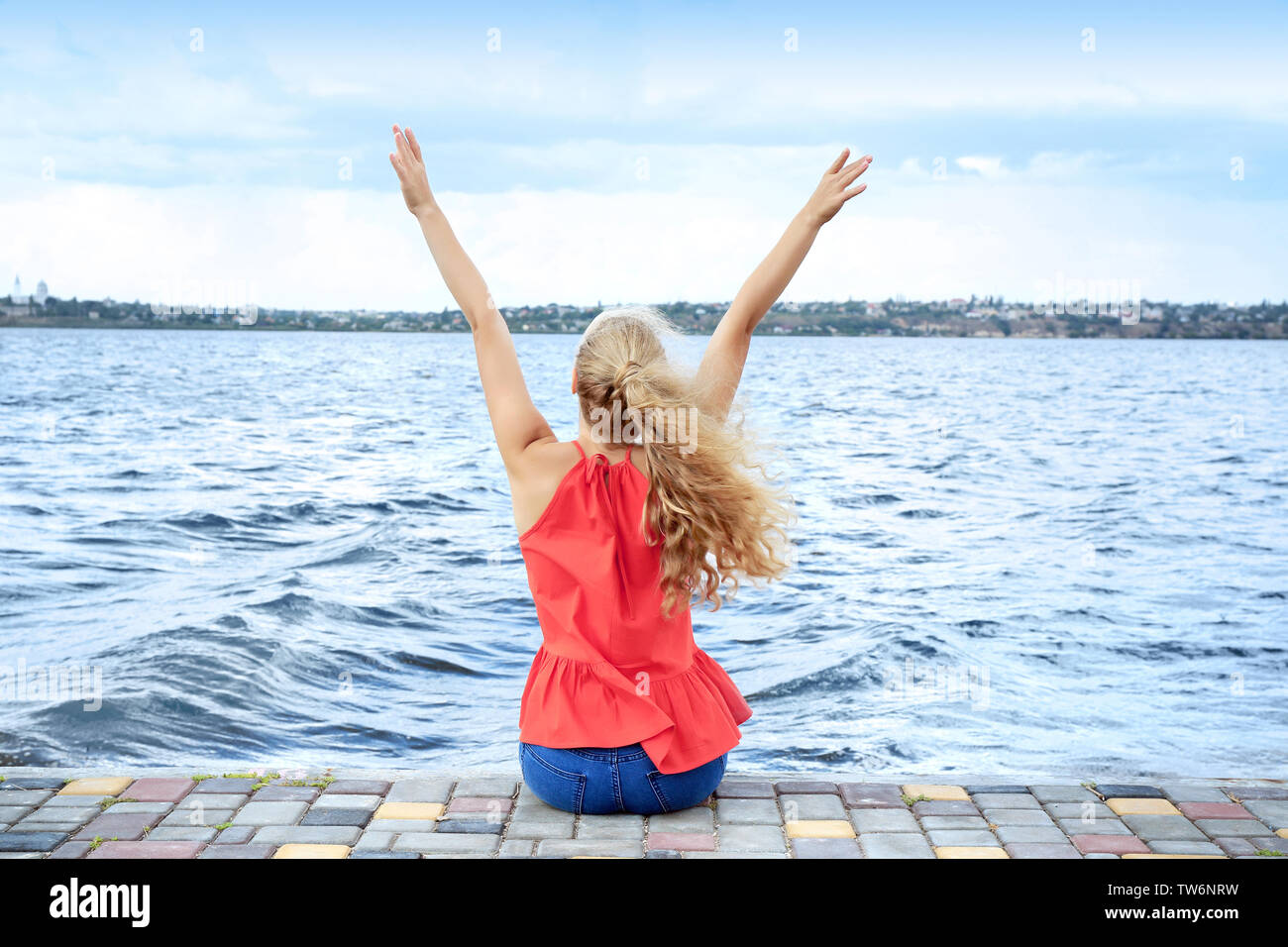 Beautiful young woman relaxing near river Stock Photo - Alamy