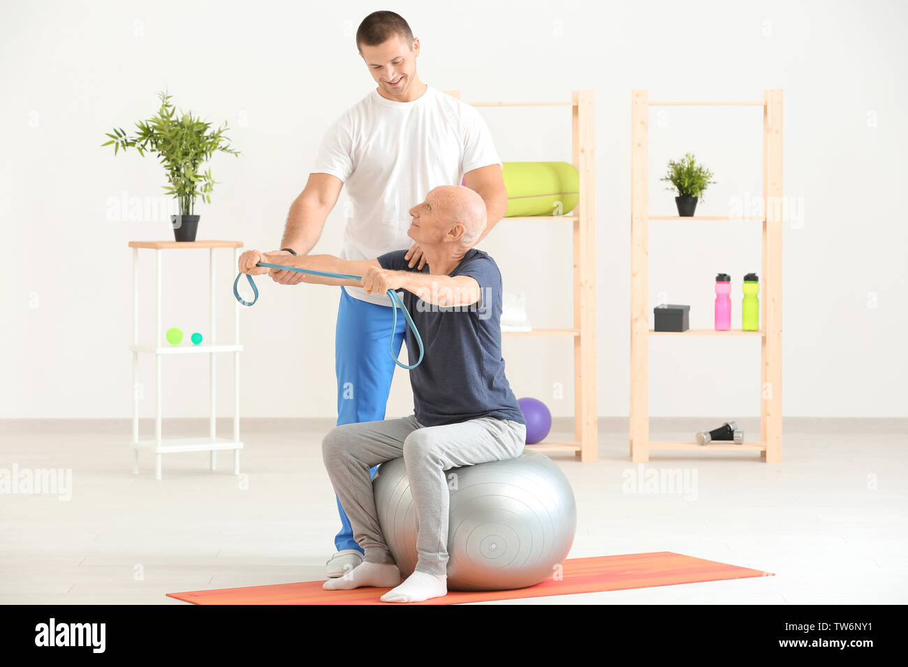 Physiotherapist working with patient in clinic Stock Photo - Alamy