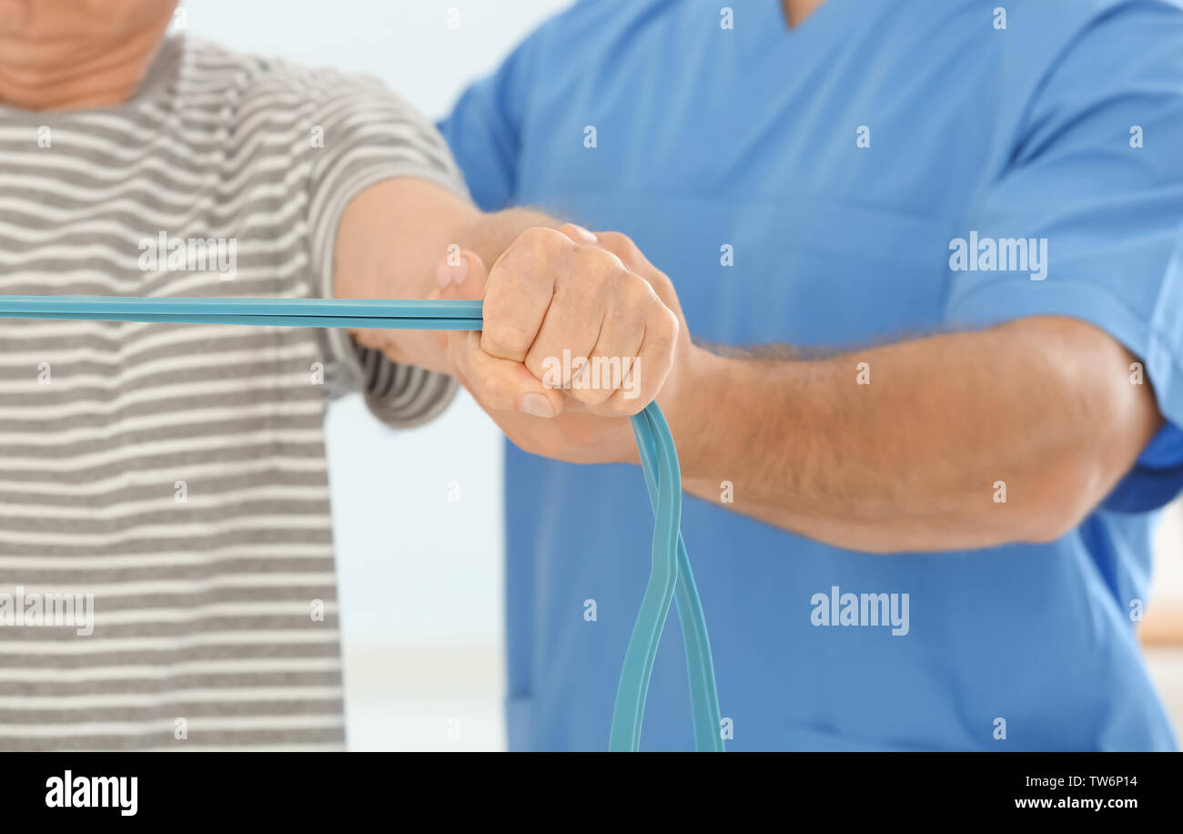 Elderly patient training with rubber band under doctor's supervision in ...
