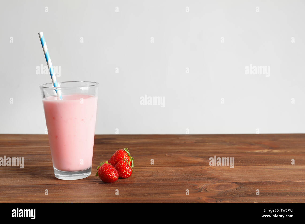 Glass of fresh protein shake on table against white background Stock ...