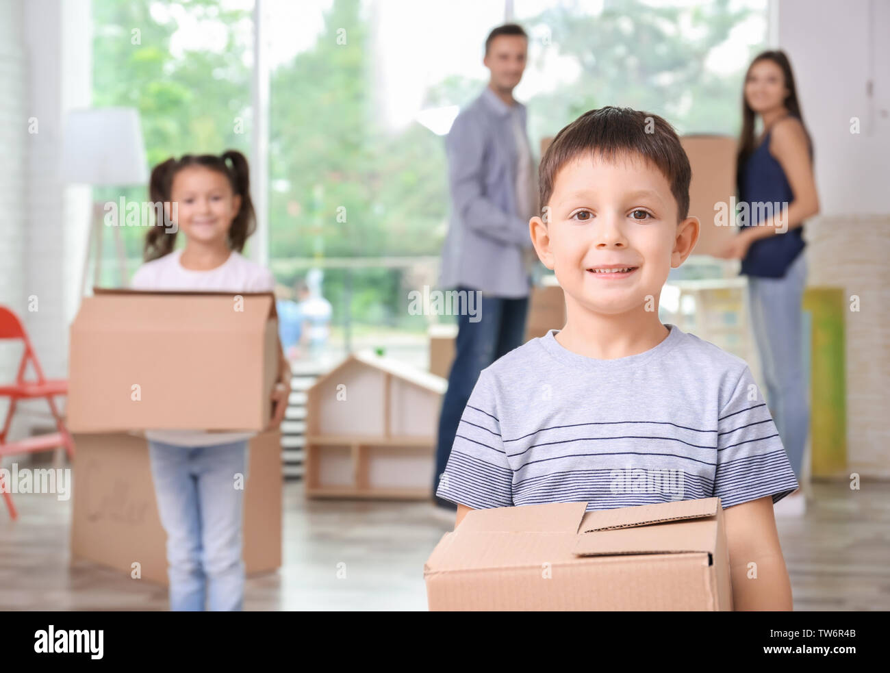 Cute little boy with moving box in room at new home Stock Photo - Alamy