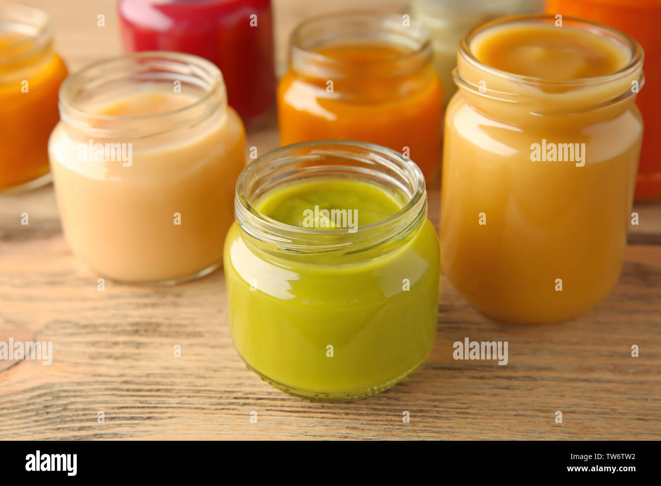 Assortment of jars with tasty baby food on wooden table Stock Photo - Alamy