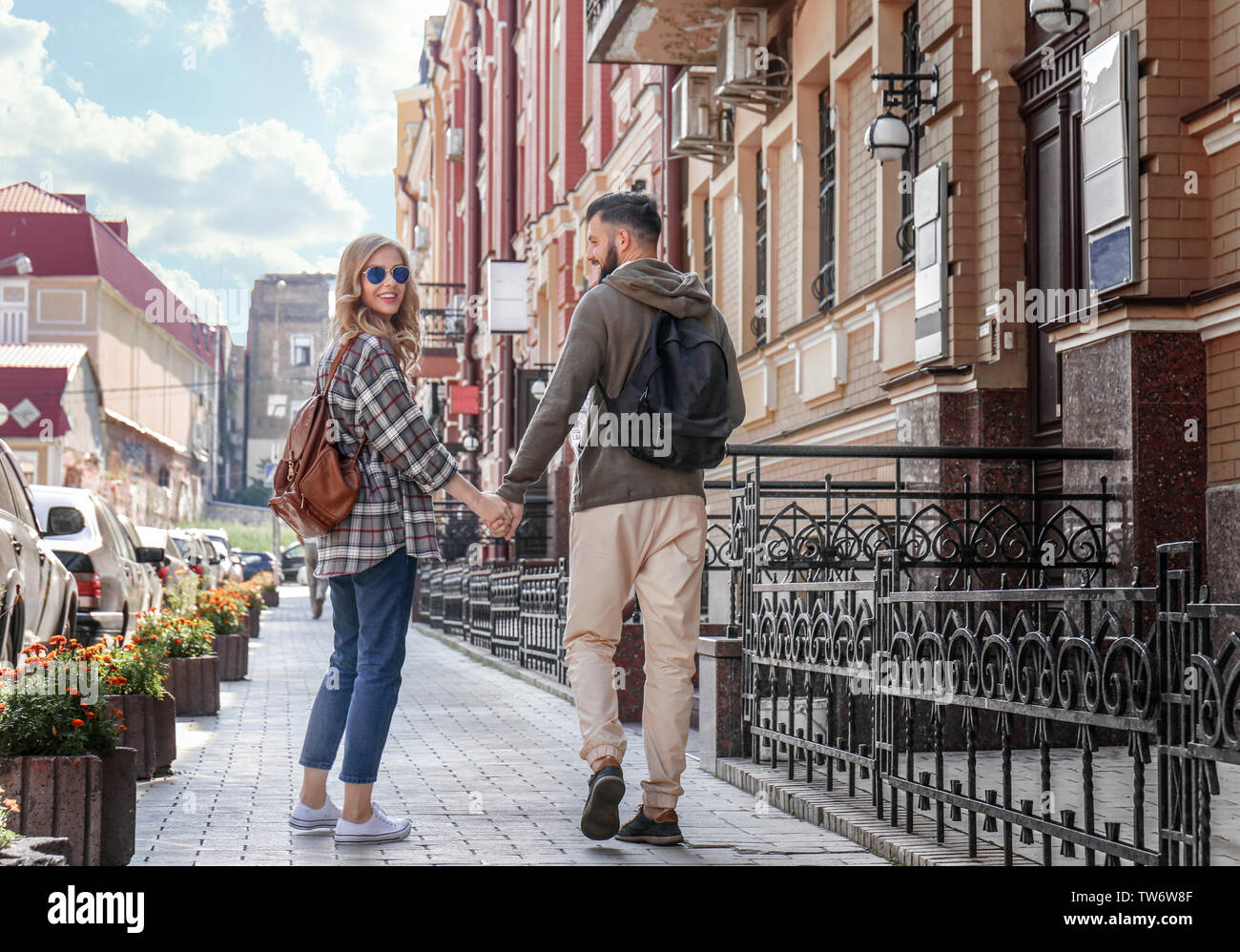 Happy young tourists walking on street in city Stock Photo - Alamy
