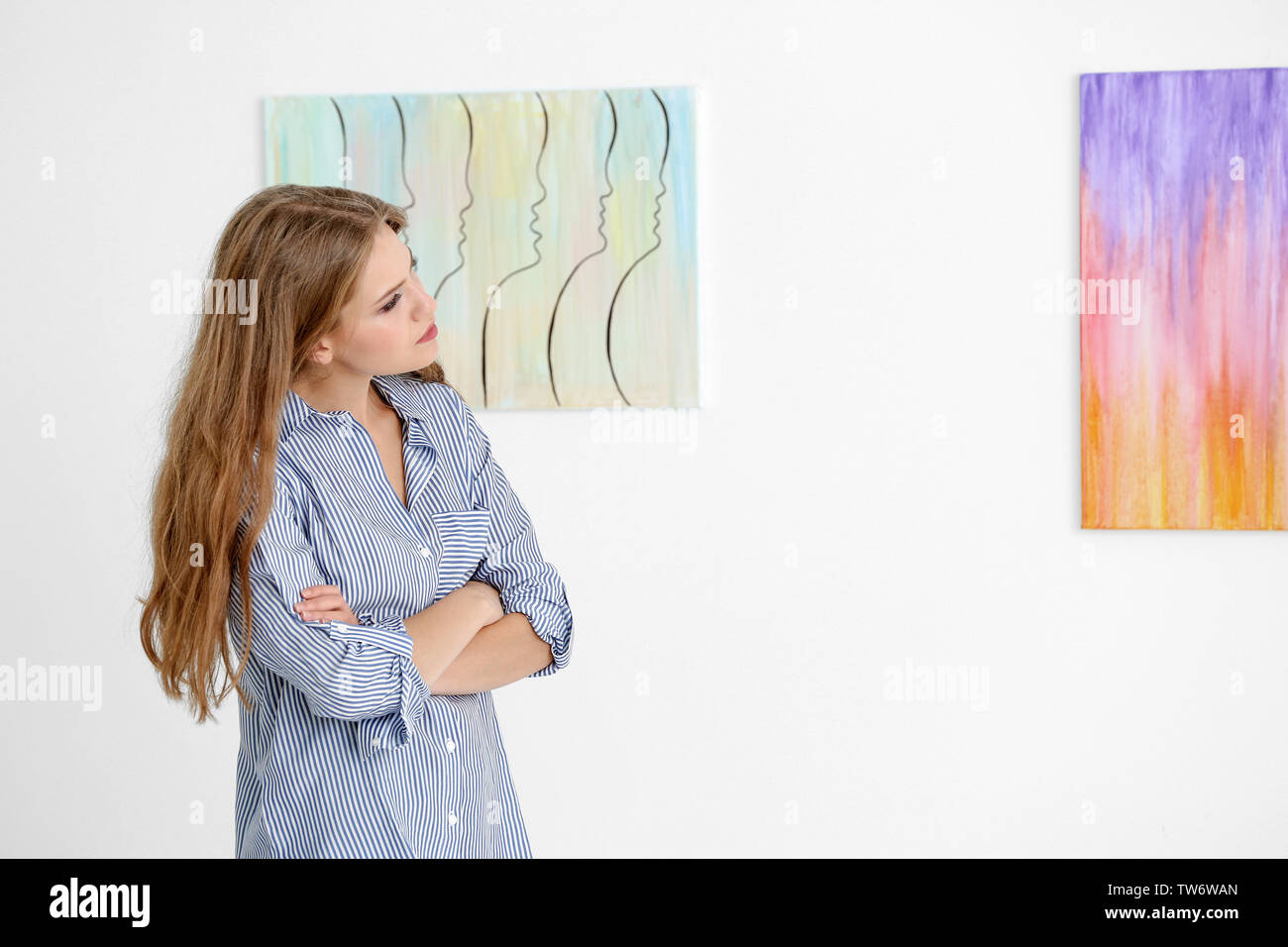 Young woman looking at painting in art gallery Stock Photo - Alamy