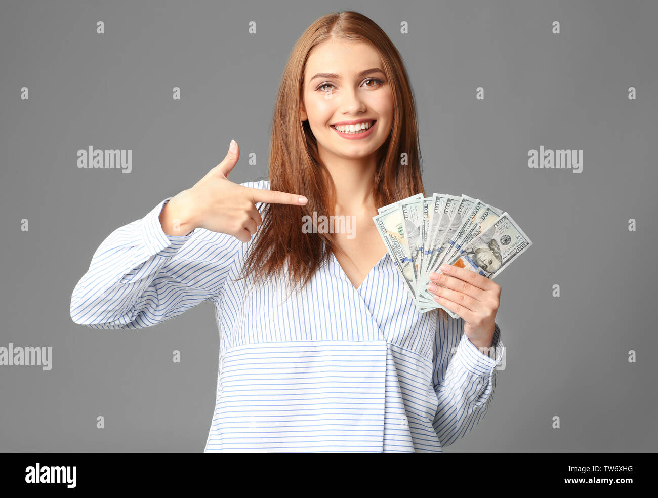 Beautiful young woman with dollar bills on grey background Stock Photo ...