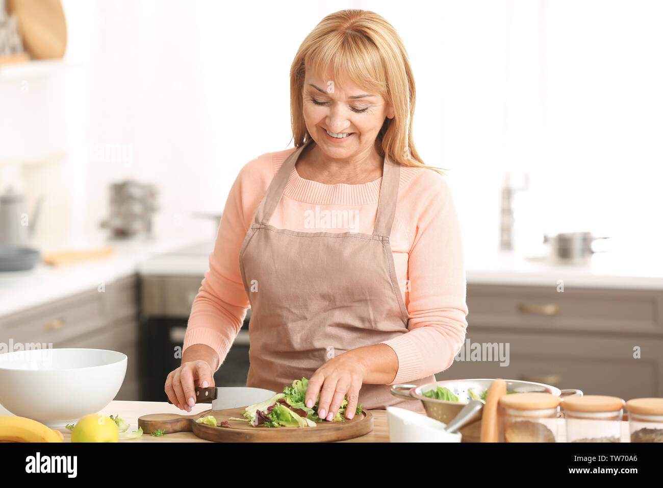 Beautiful mature woman cooking in kitchen Stock Photo - Alamy