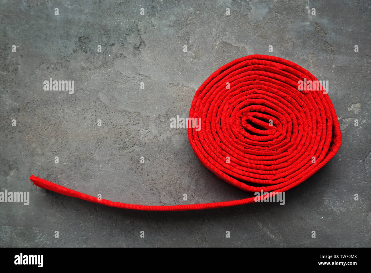 Red karate belt on grey background Stock Photo - Alamy