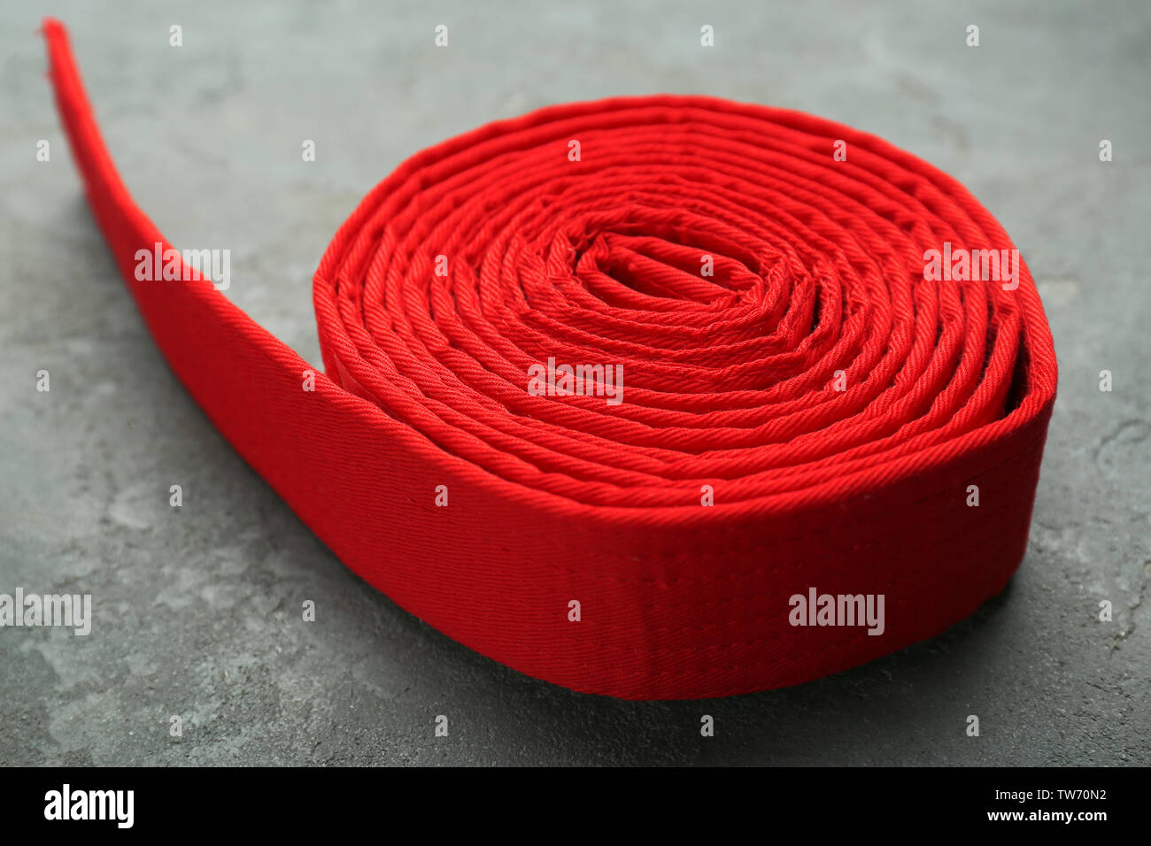 Red karate belt on grey background Stock Photo - Alamy