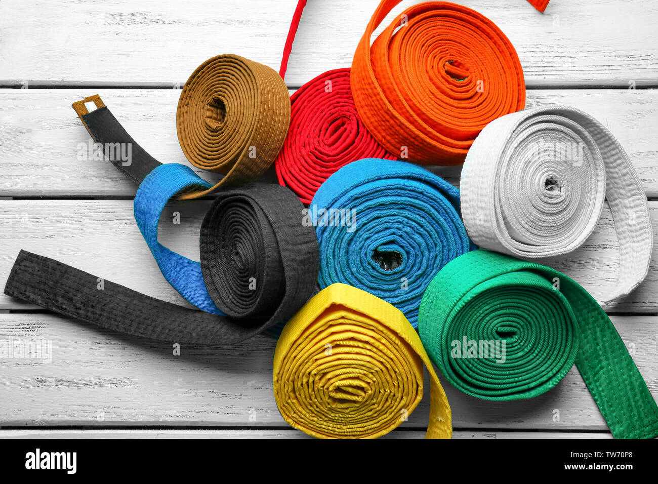 Colorful karate belts on wooden background Stock Photo - Alamy