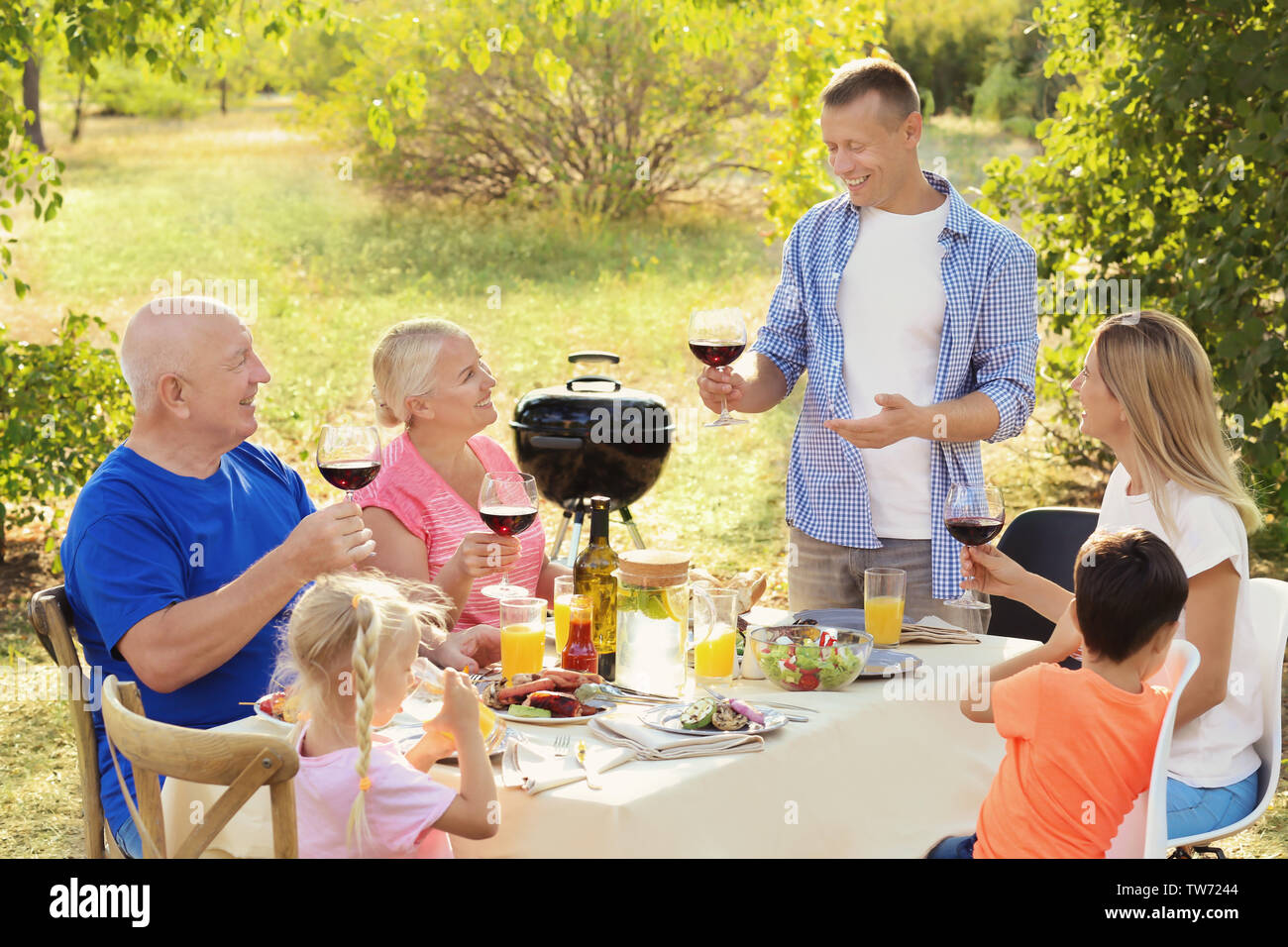 Happy family having barbecue party outdoors Stock Photo - Alamy