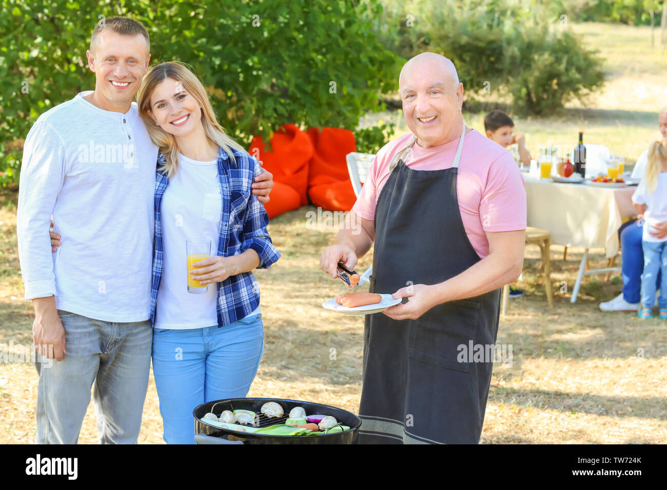 Happy family having barbecue party outdoors Stock Photo - Alamy