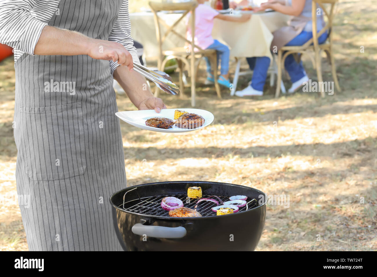 Man cooking tasty steaks on barbecue grill outdoors Stock Photo - Alamy