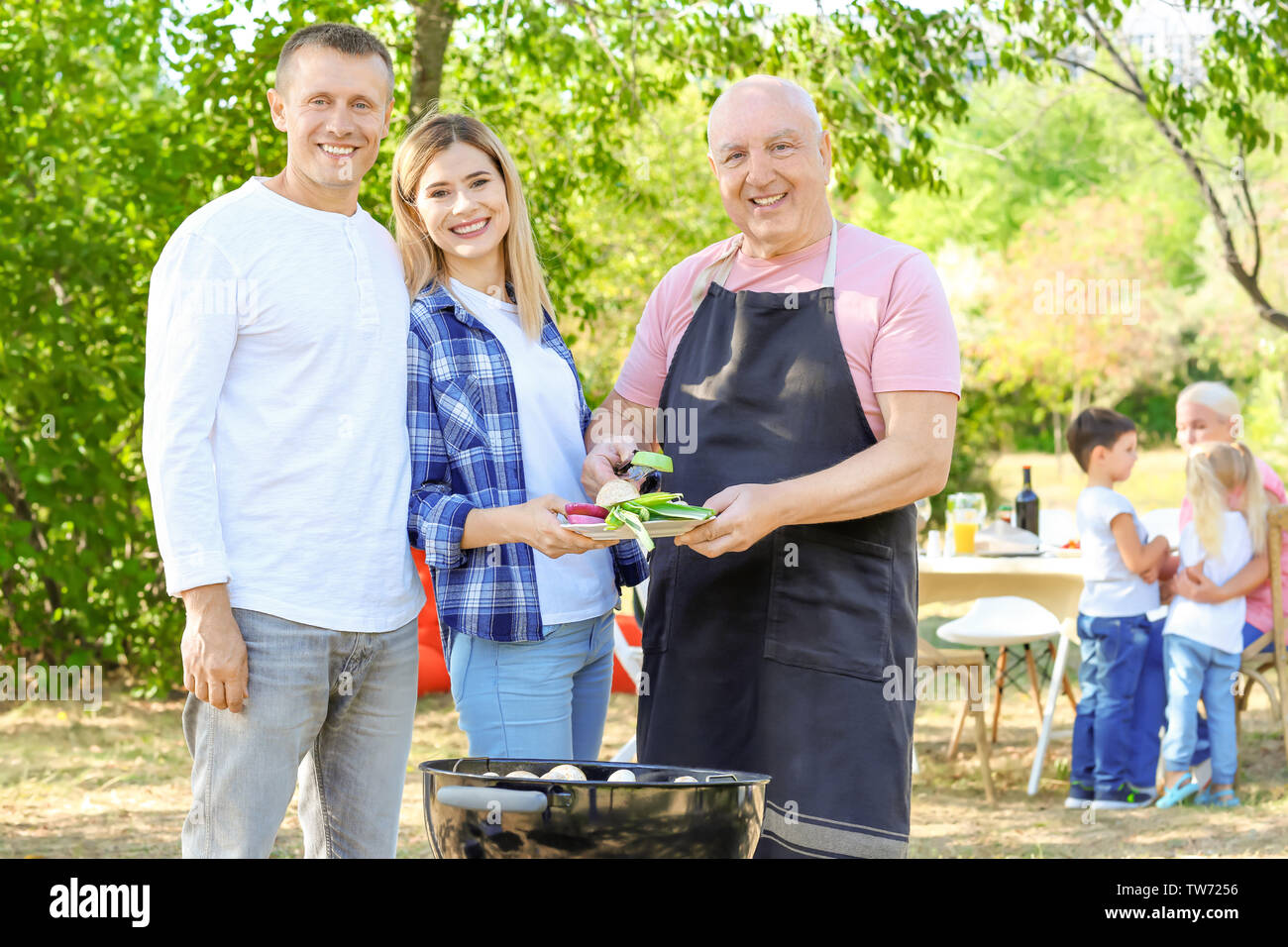 Happy family having barbecue party outdoors Stock Photo - Alamy