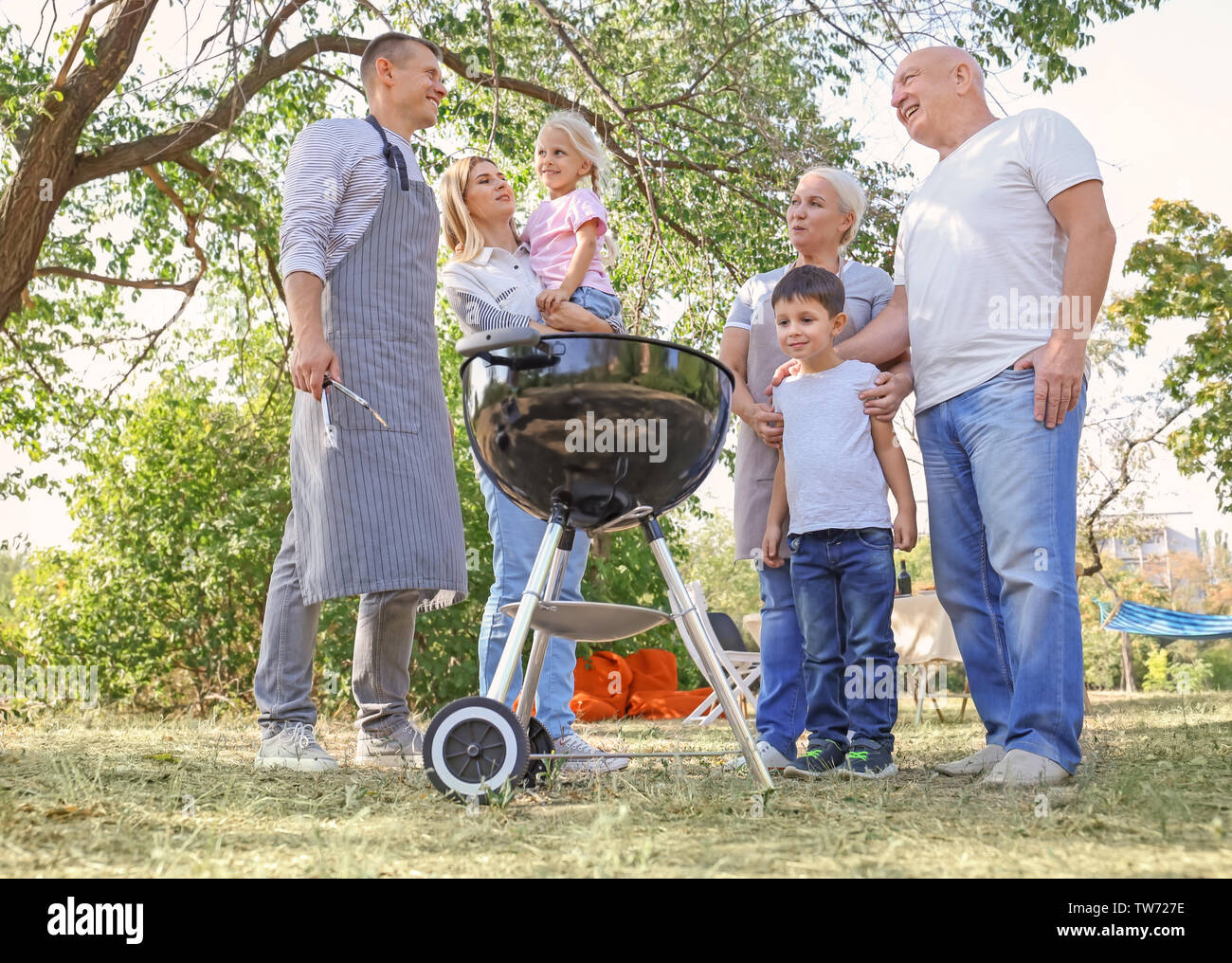 Happy family having barbecue party outdoors Stock Photo - Alamy