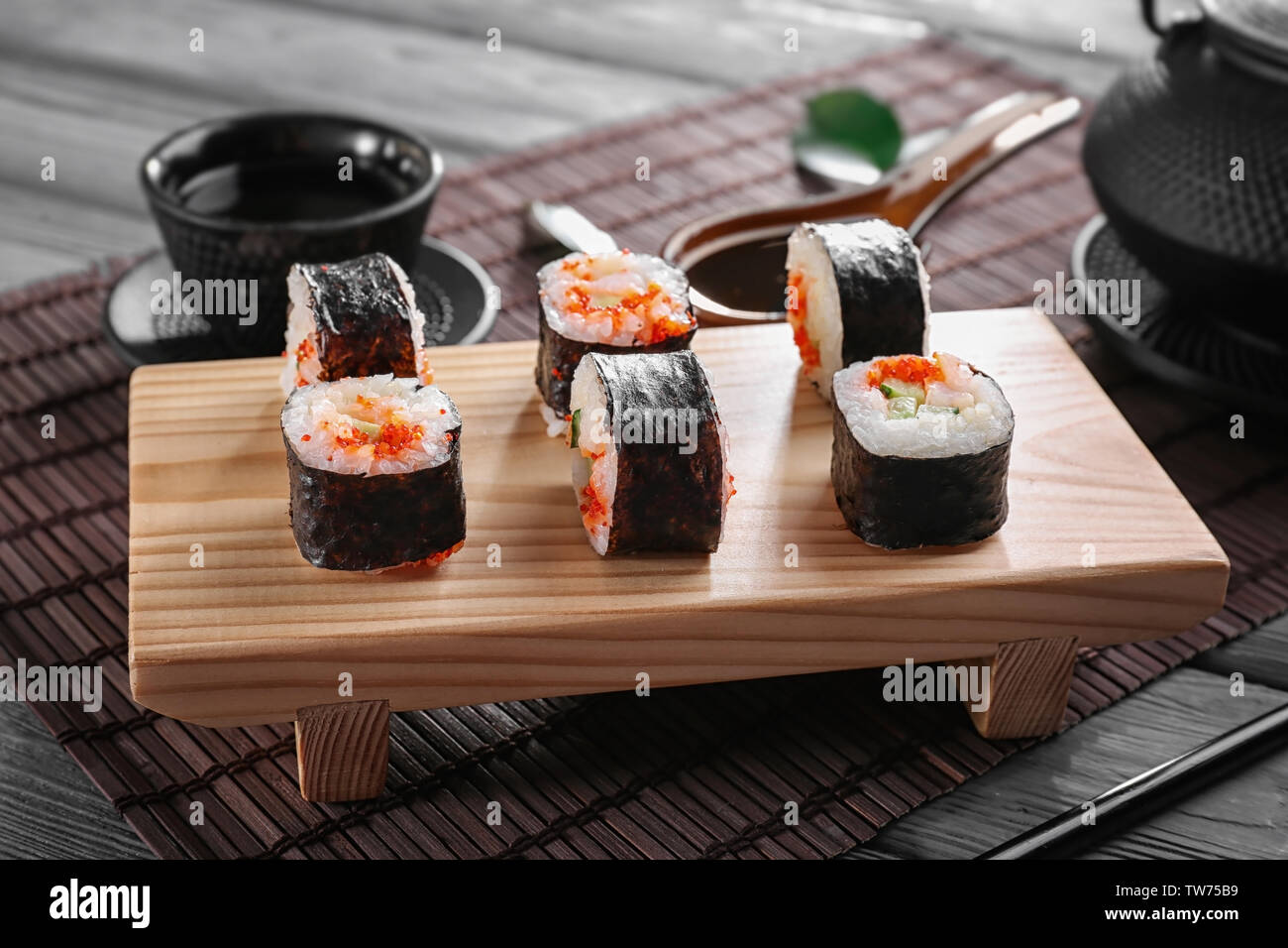 Stand with tasty sushi rolls on table Stock Photo - Alamy