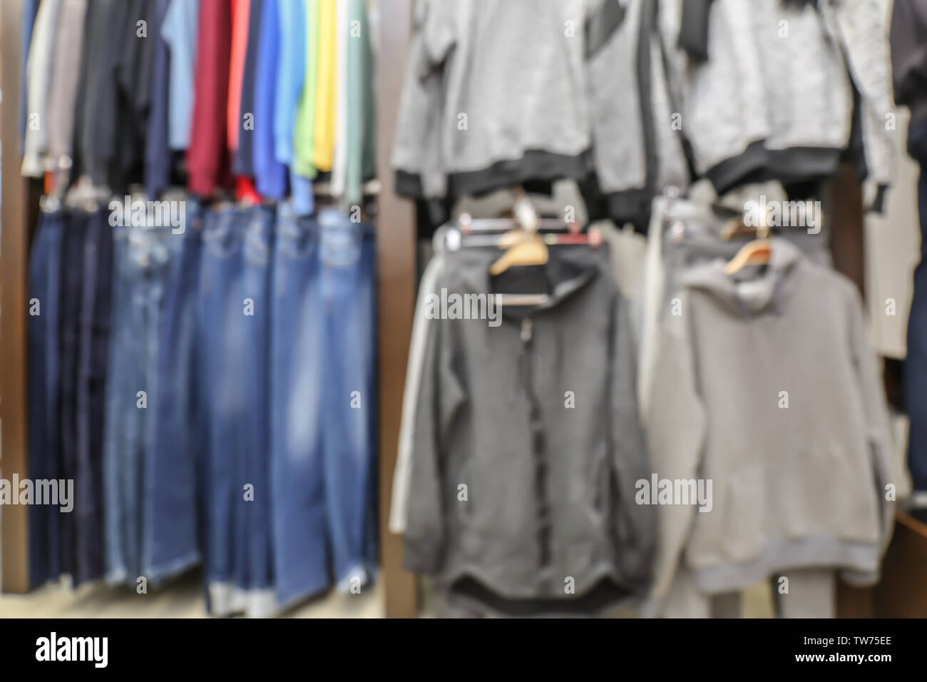 Blurred view of different clothes in modern store Stock Photo - Alamy
