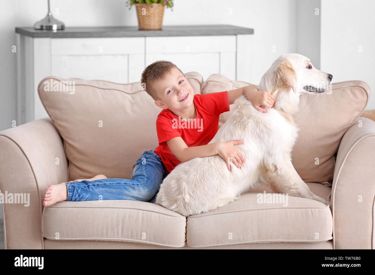 Cute little boy with dog at home Stock Photo - Alamy