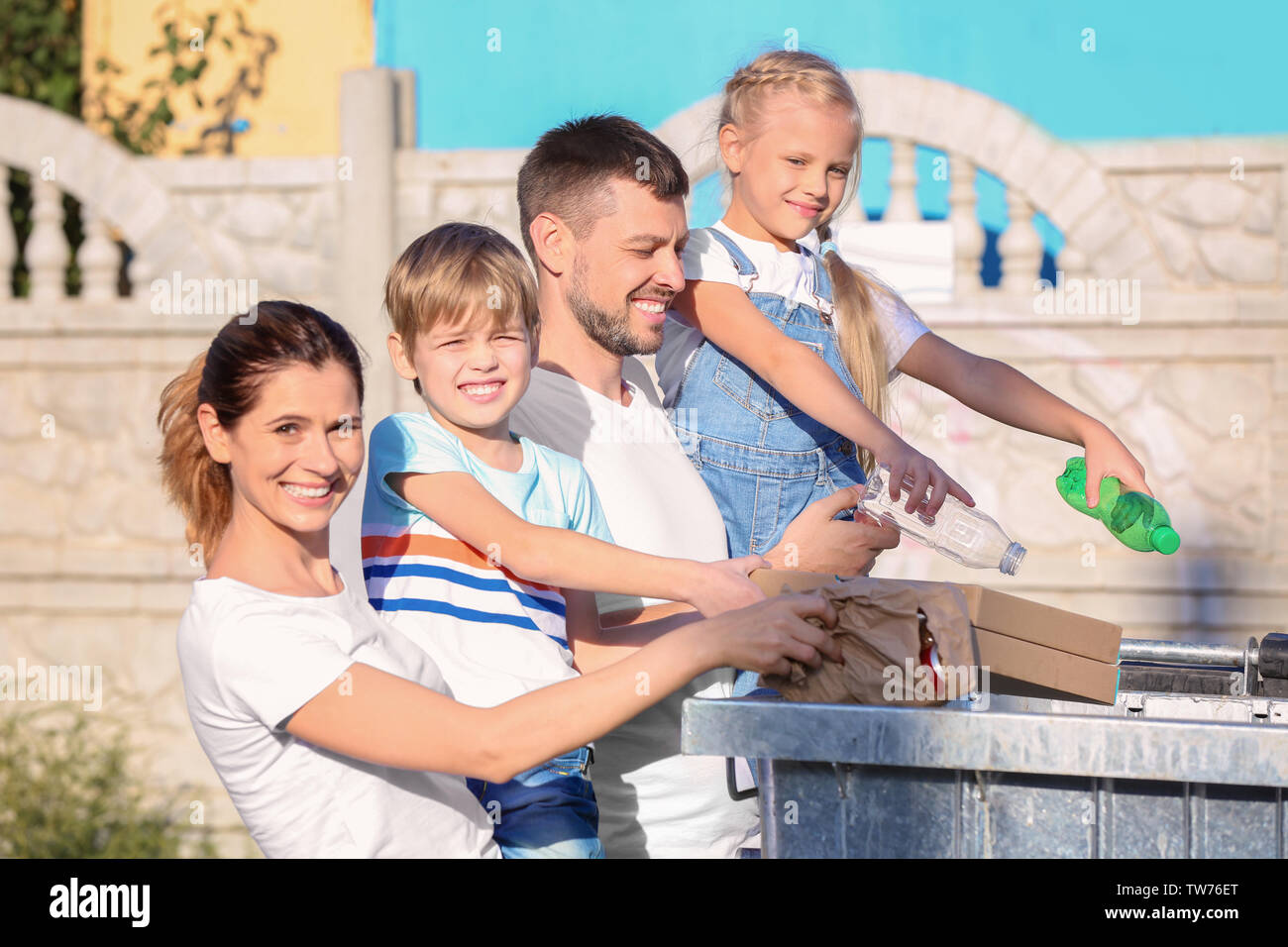 Family throwing garbage in metal container outdoors Stock Photo - Alamy