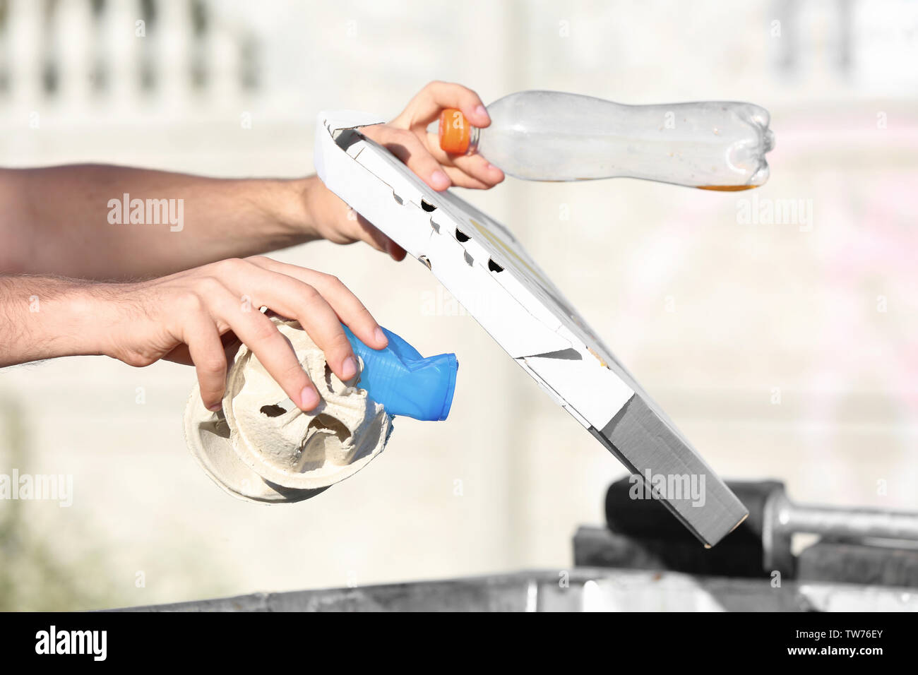 Man throwing garbage in metal container outdoors, closeup Stock Photo ...