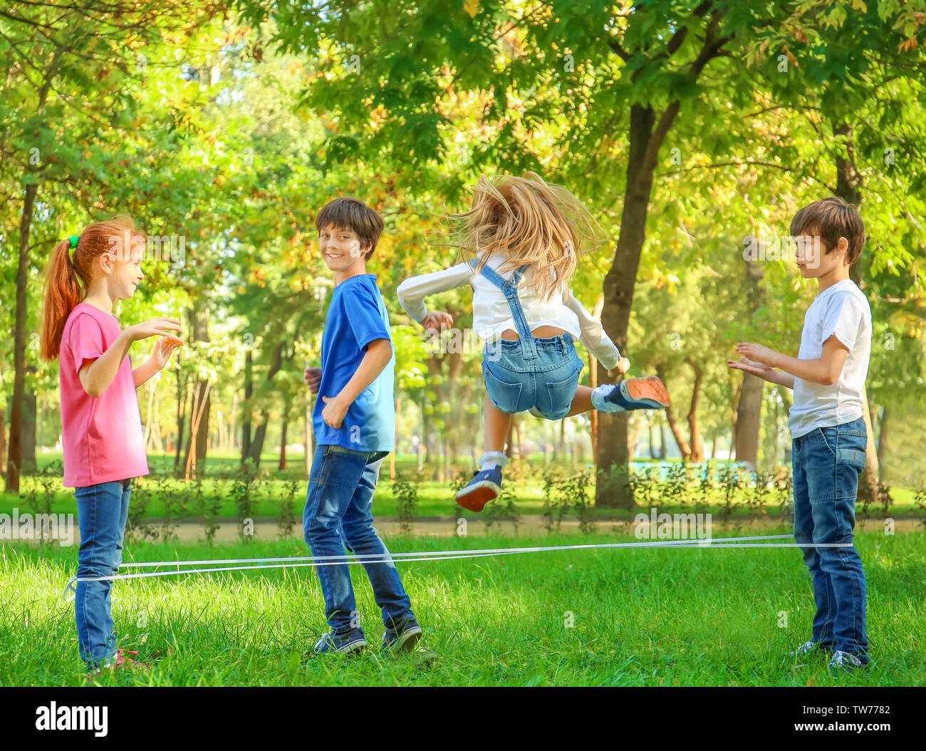 Cute little children jumping rope in park Stock Photo - Alamy
