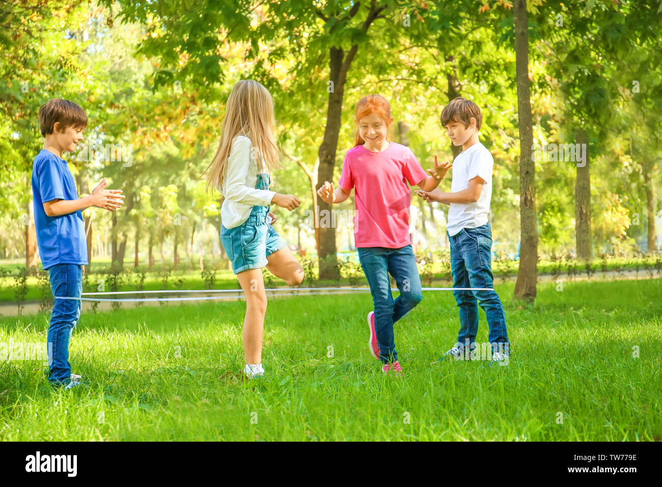 Cute little children jumping rope in park Stock Photo - Alamy