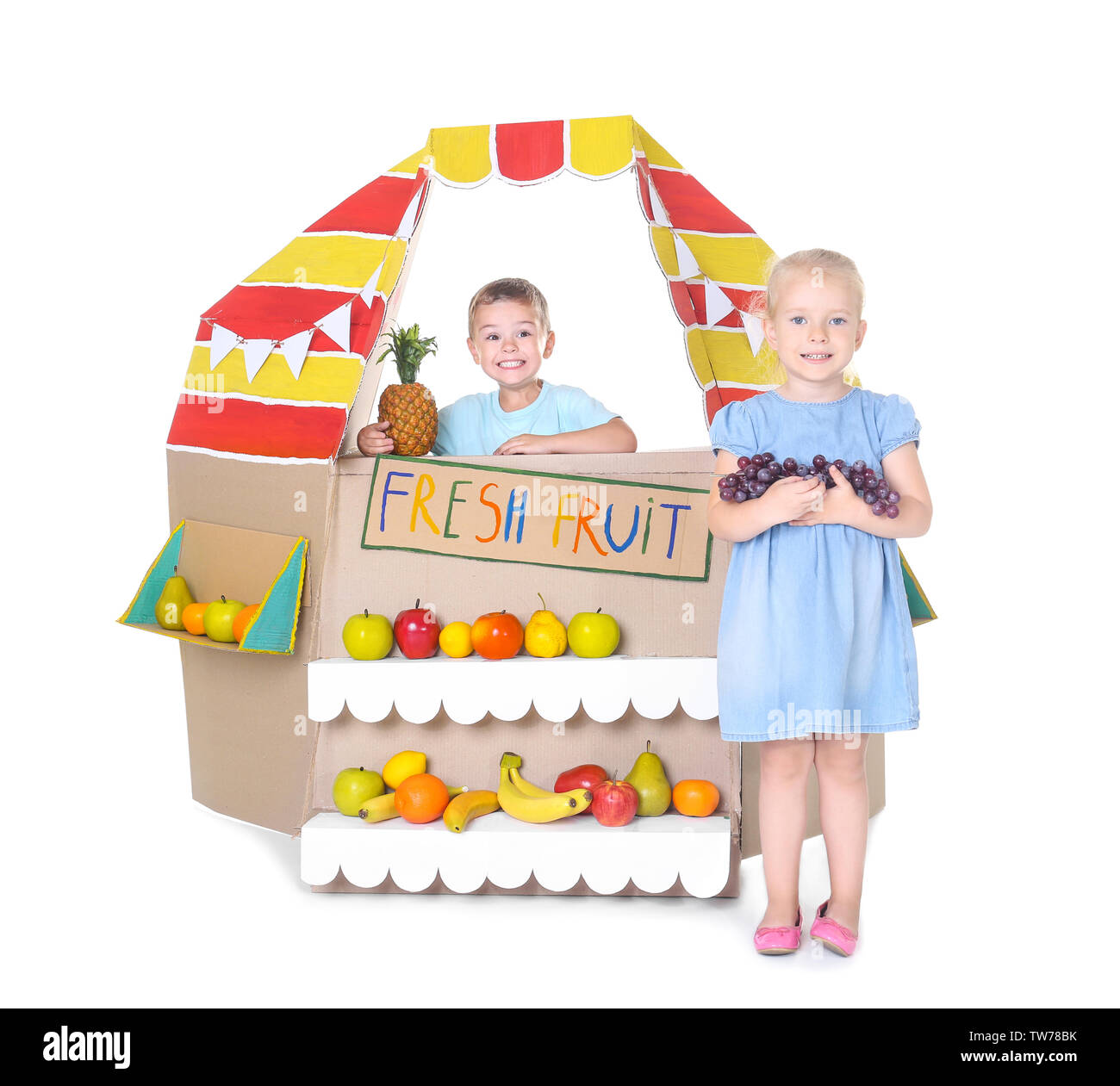 Little children playing with cardboard stall on white background Stock ...