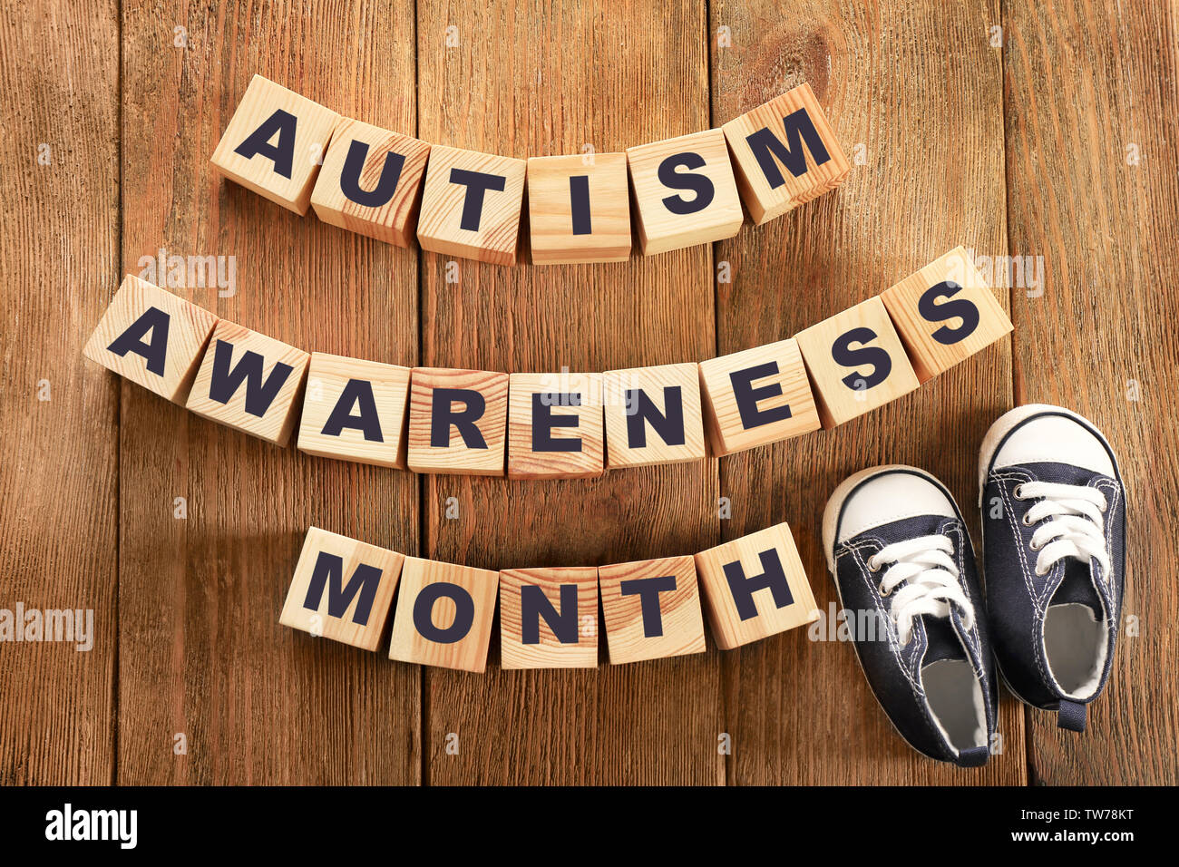 Cubes with booties on wooden background. Autism concept Stock Photo - Alamy