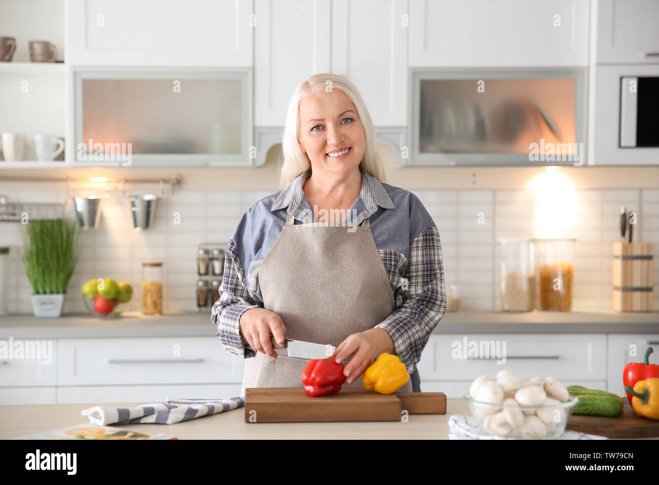 Beautiful mature woman cooking in kitchen Stock Photo - Alamy