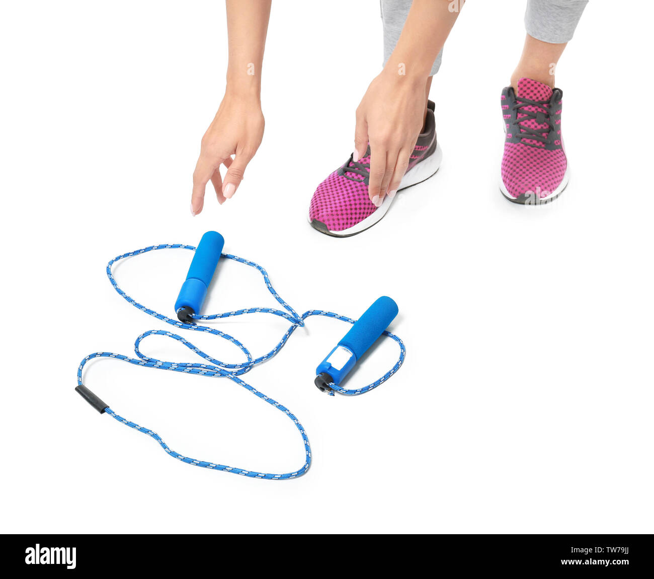 Young woman reaching for jumping rope on white background Stock Photo ...