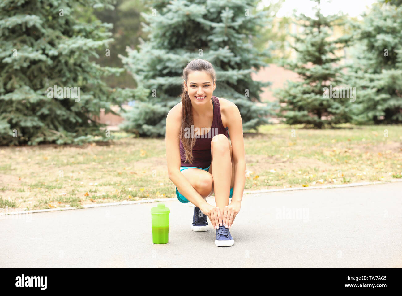Beautiful young woman with protein shake in park Stock Photo - Alamy