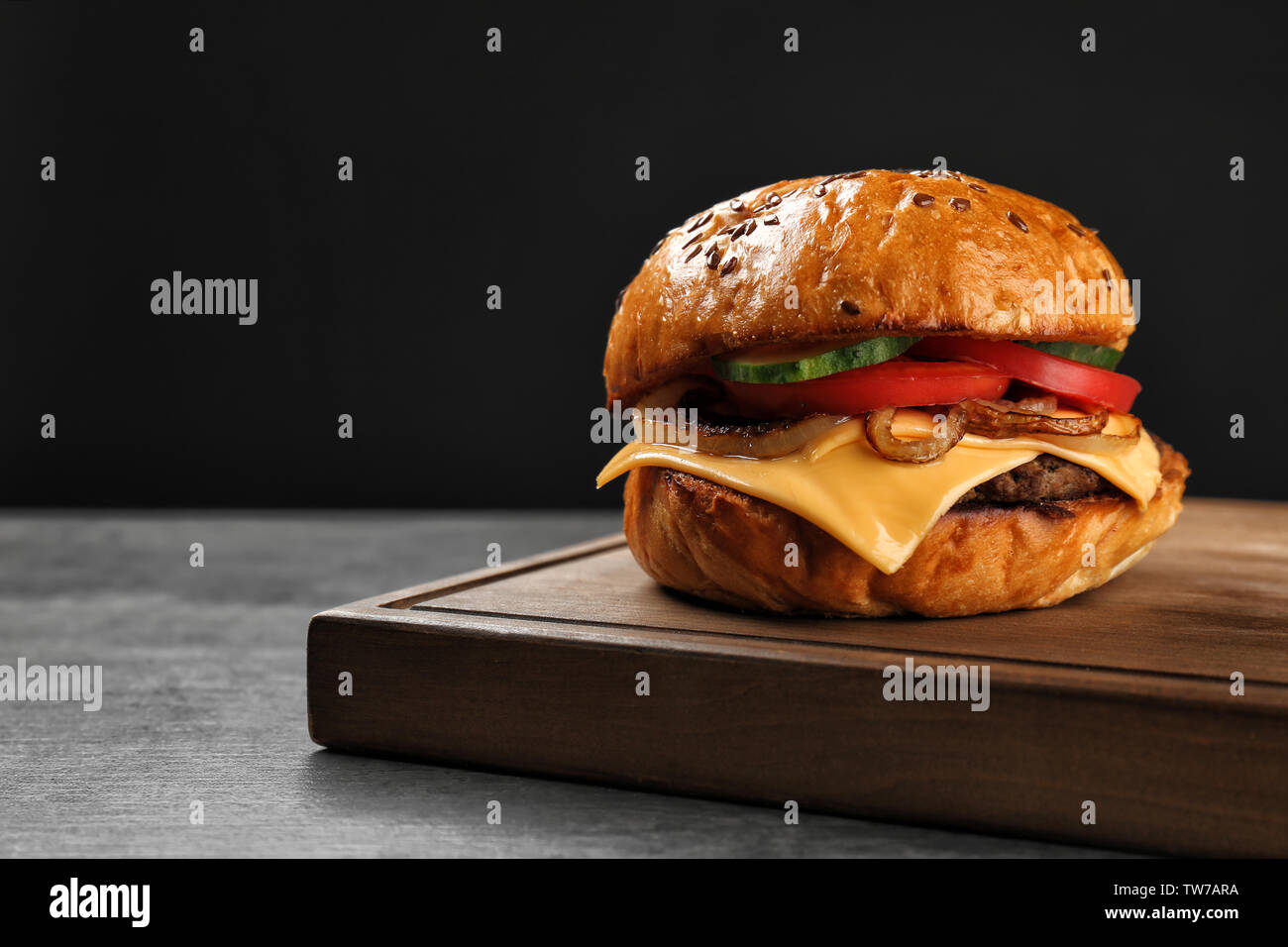 Wooden board with tasty burger on table Stock Photo - Alamy