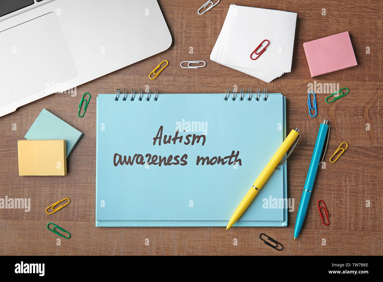 Words "Autism awareness day" written in notebook on wooden table Stock ...