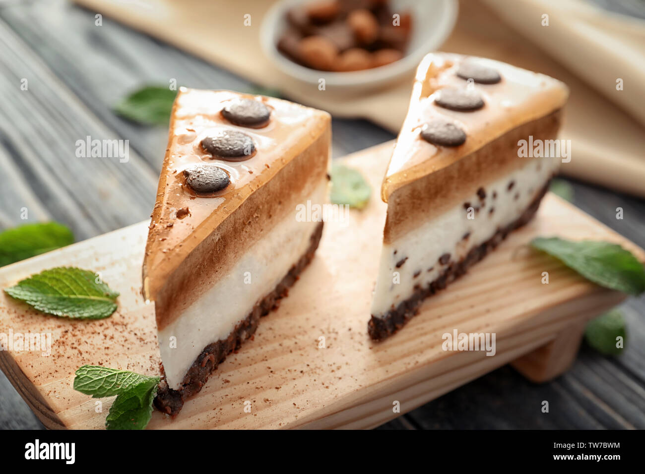 Pieces of layered mousse cake with caramel on wooden board Stock Photo ...