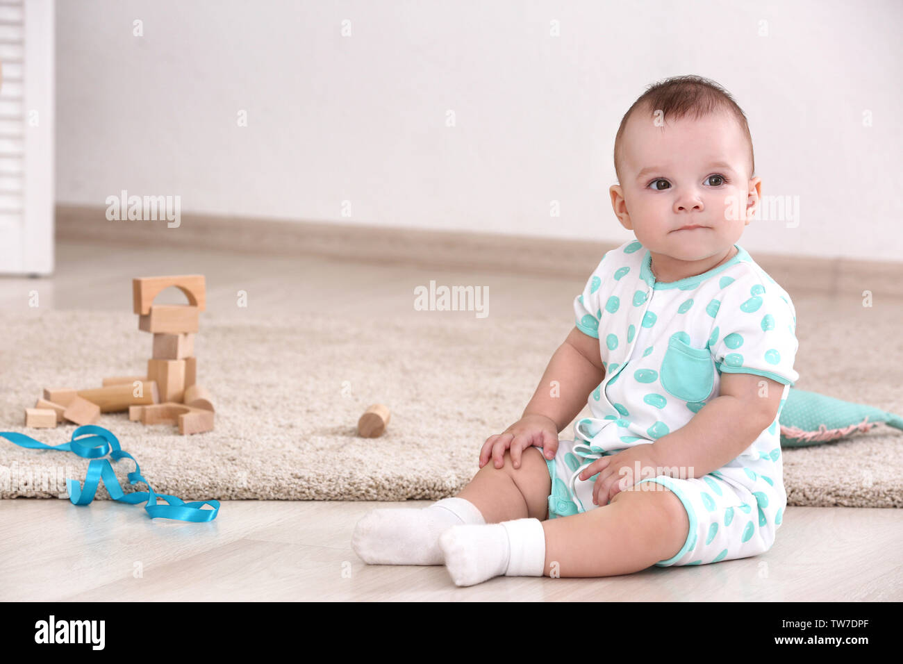 Cute baby sitting on floor at home Stock Photo - Alamy