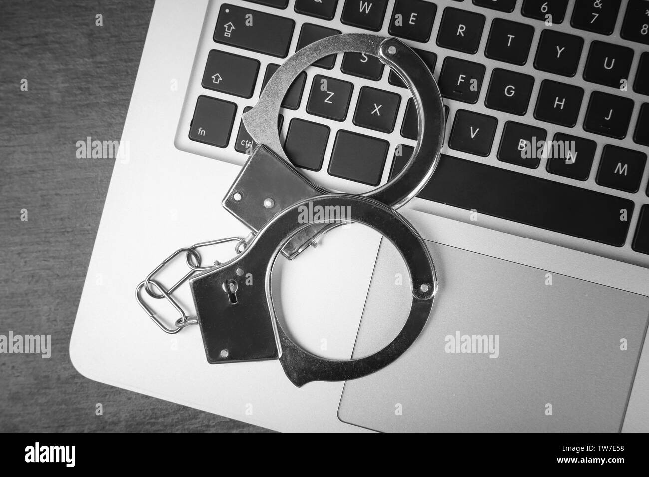 Handcuffs on laptop keyboard, close up Stock Photo - Alamy
