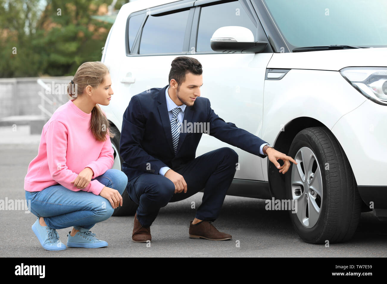 Salesman showing new car to customer outdoors Stock Photo - Alamy