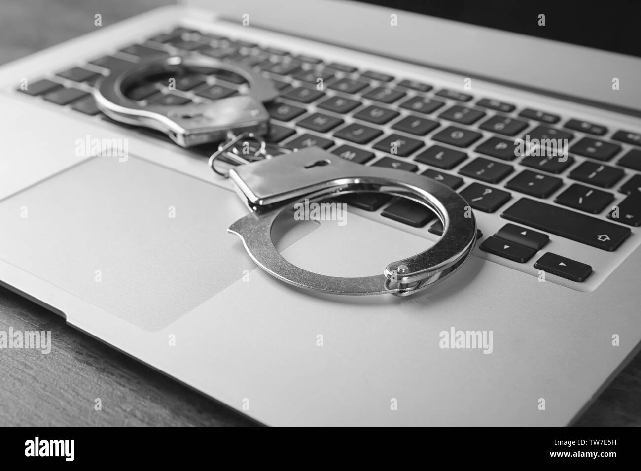 Handcuffs on laptop keyboard, close up Stock Photo - Alamy
