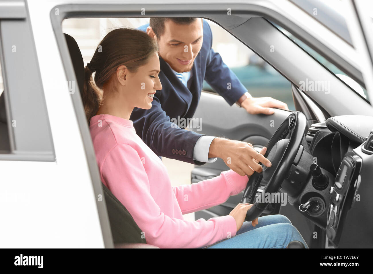 Salesman showing new car to customer Stock Photo - Alamy