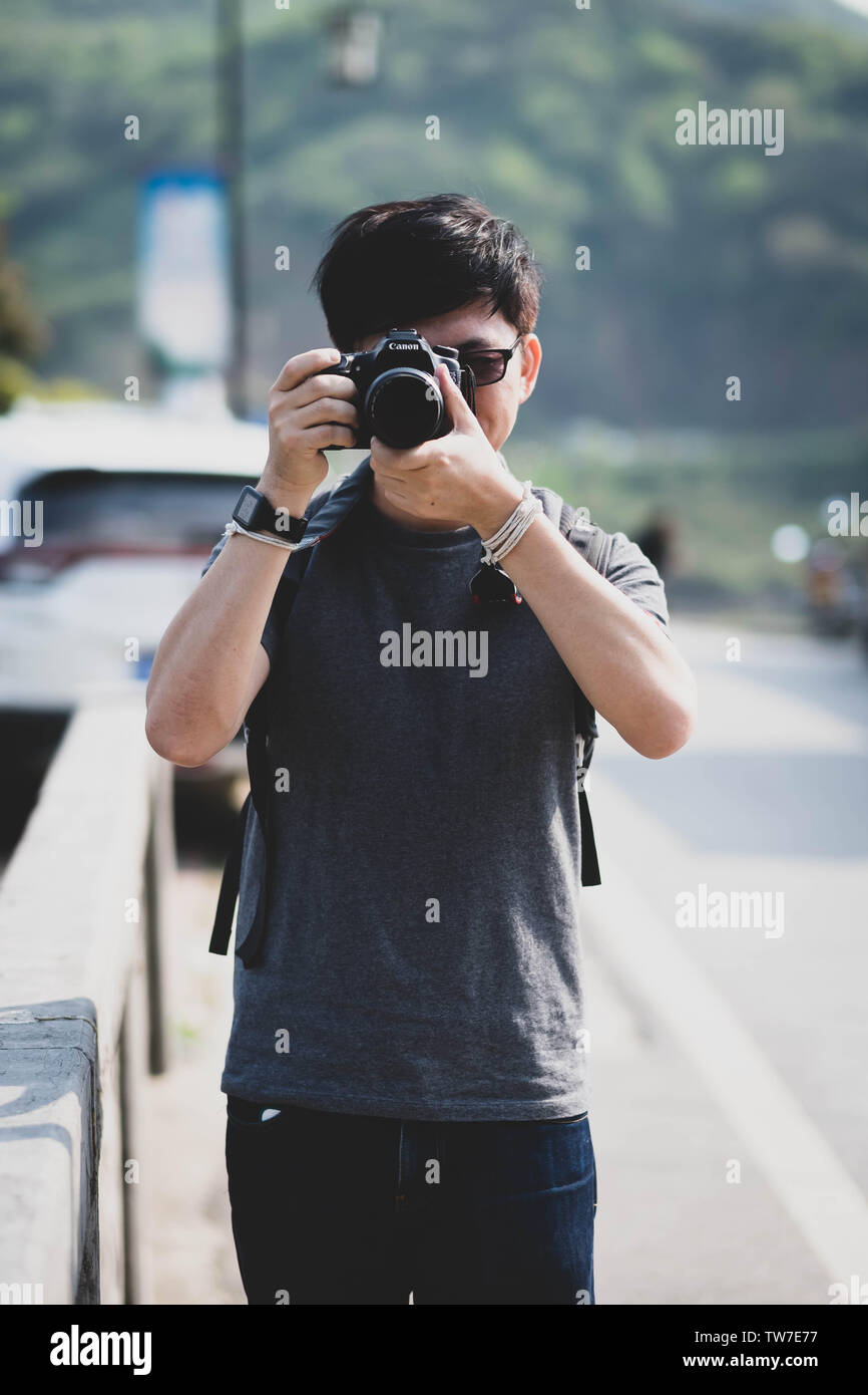 Unspecific man with a camera in his hands walks around the city and ...