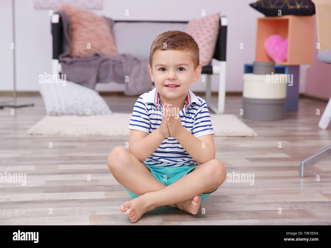 Cute little boy sitting on floor at home Stock Photo - Alamy