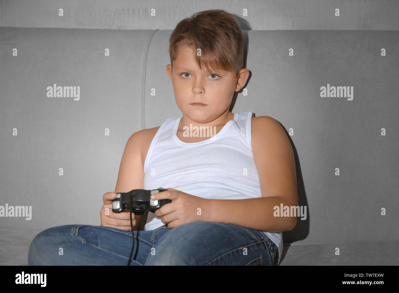 Overweight boy playing video game at home Stock Photo - Alamy