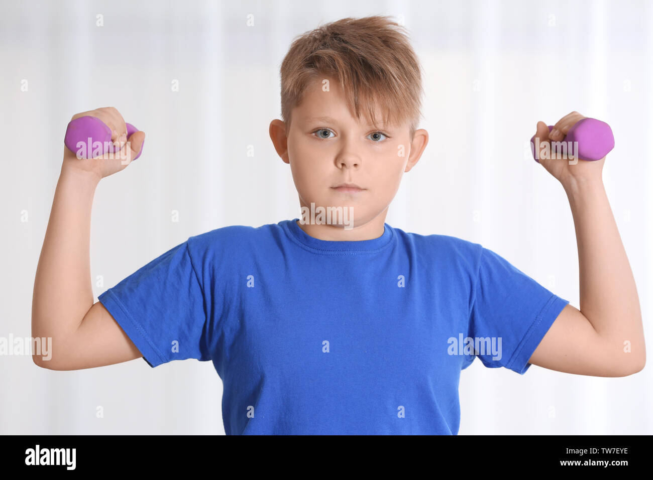 Overweight boy with dumbbells training at home Stock Photo - Alamy
