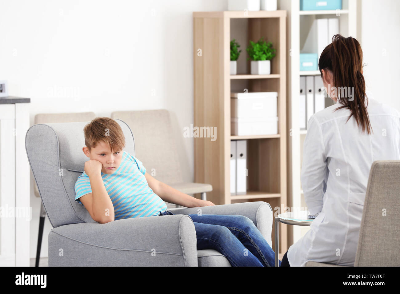 Female psychologist working with overweight boy in office Stock Photo ...